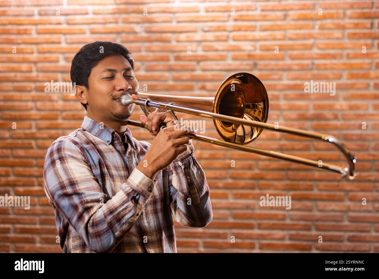 Focused musician plays the trombone with skill and passion, immersed in ...