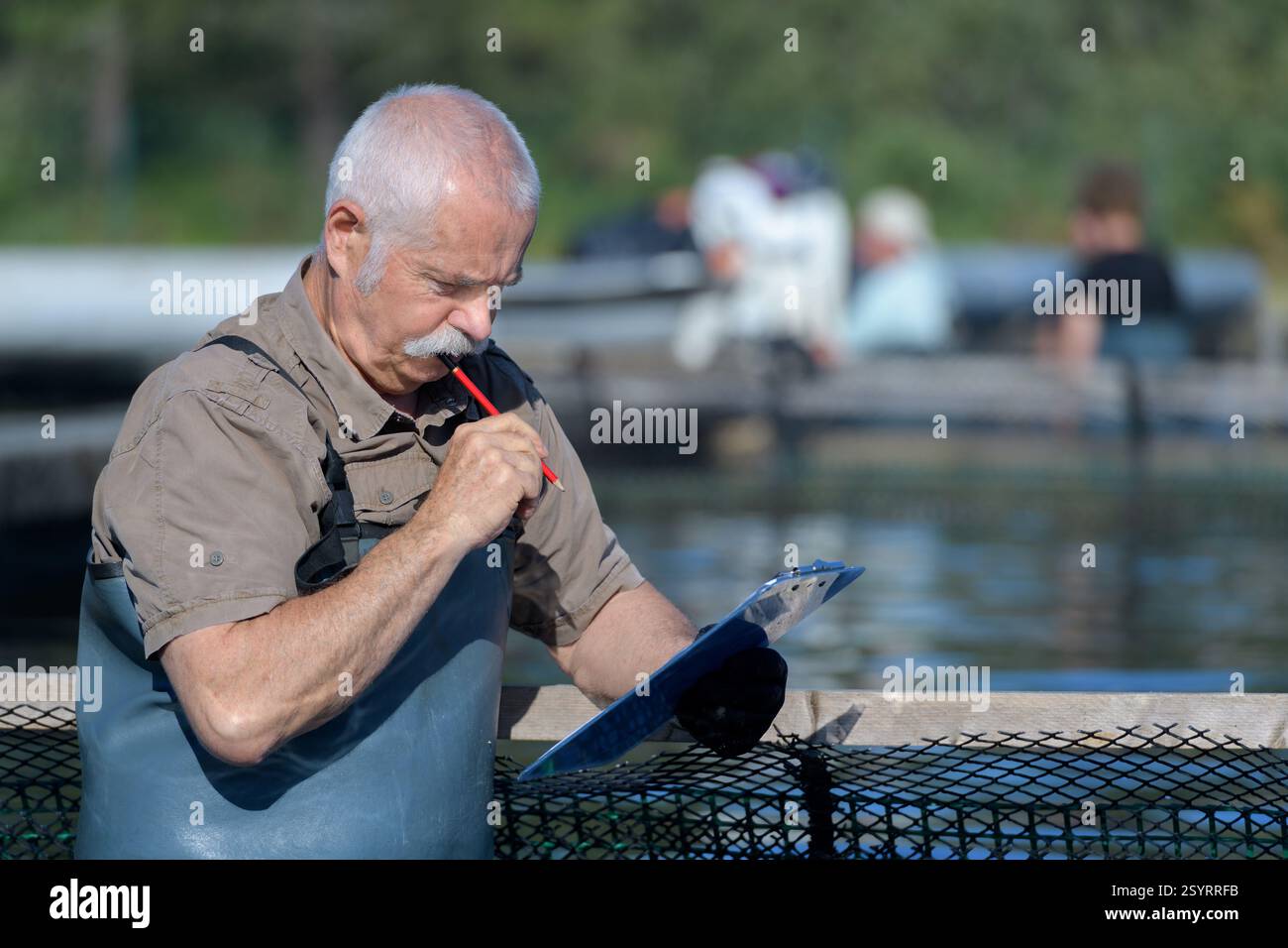 aquaculture worker studying his clipboard Stock Photo - Alamy