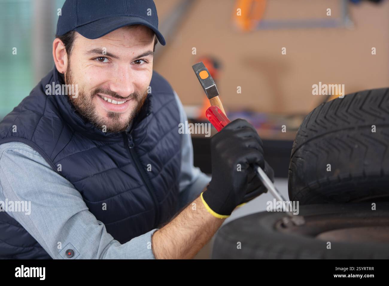 mechanic repairing car tyre in garage Stock Photo - Alamy