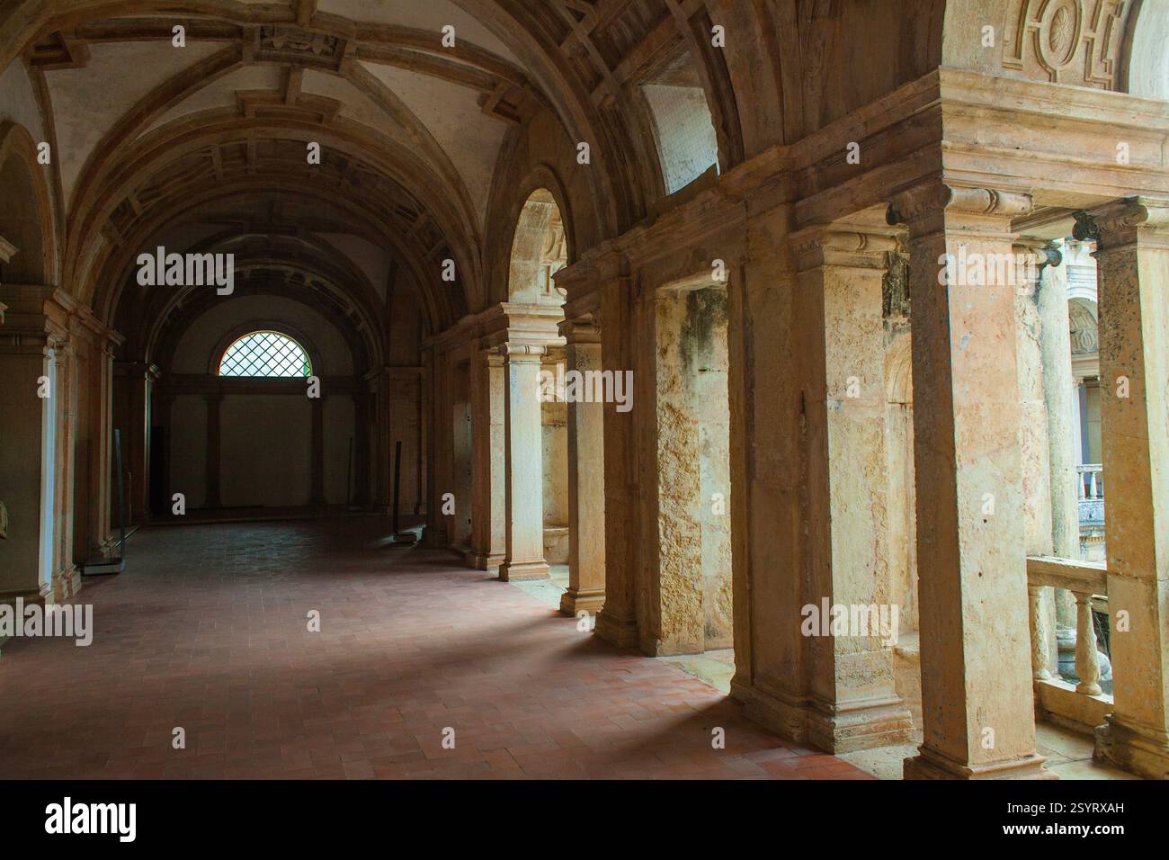 view down a long, arched colonnade within a historic building, creating ...
