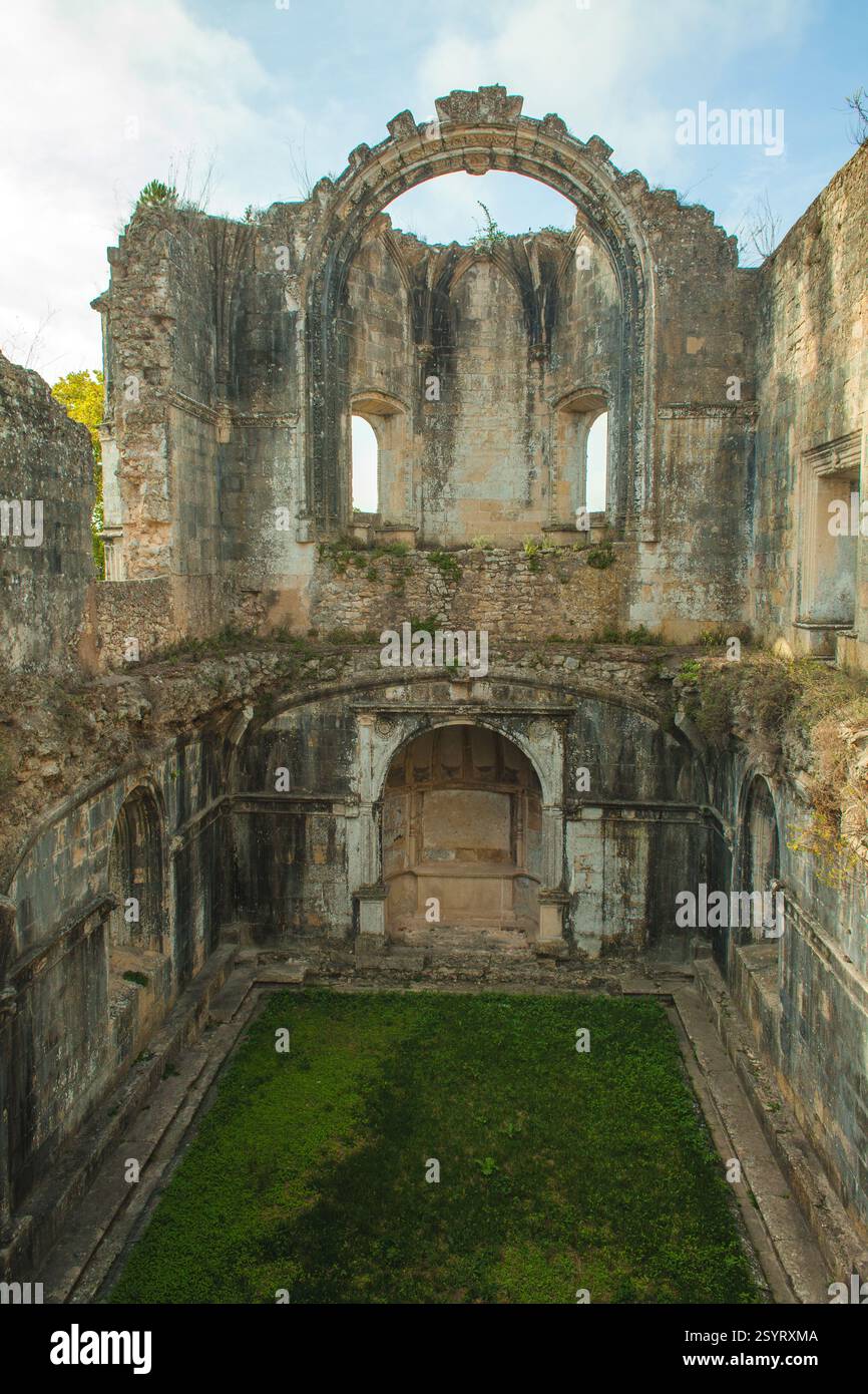 ruined interior space with crumbling walls, arched windows, and a patch ...