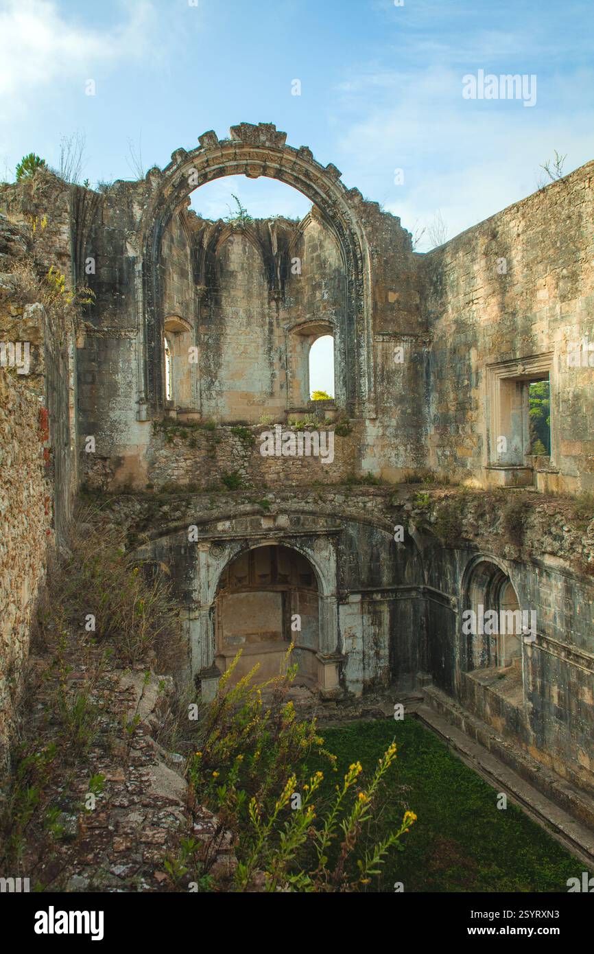 ruined interior space with crumbling walls, arched windows, and a patch ...