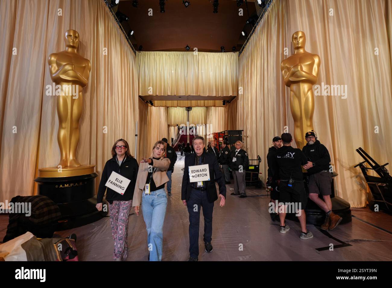 Stand-ins walk past Oscar statues in the red carpet area before the ...