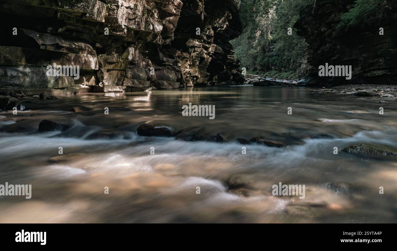 This image captures a fast-flowing river rushing over a rocky bed ...