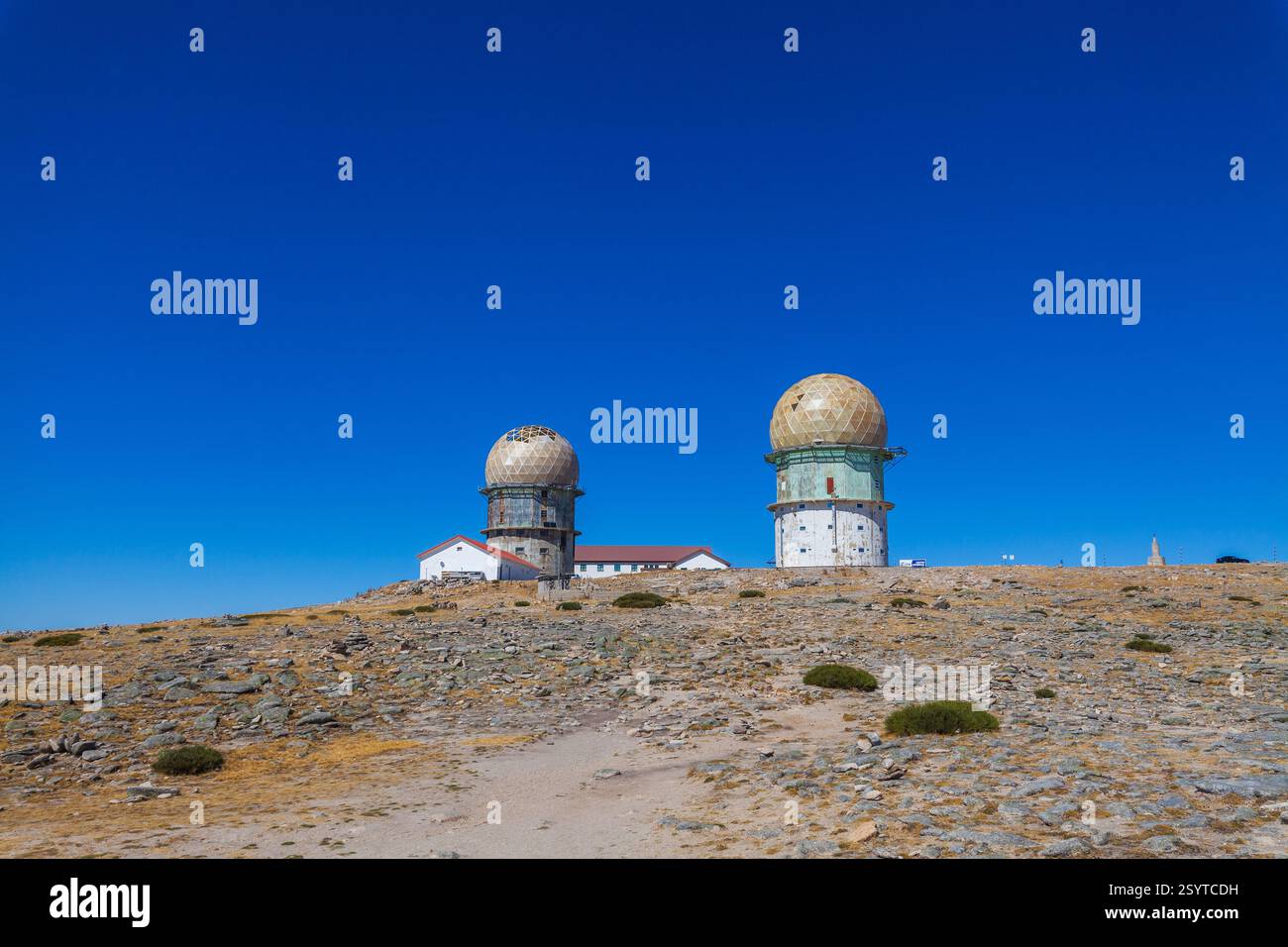 Two distinctive domed structures stand atop a barren, rocky hill ...