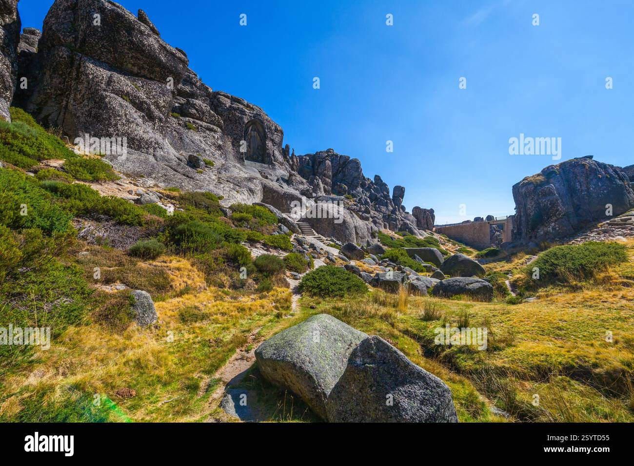 A rugged mountain landscape with rocky outcrops, sparse vegetation, and ...
