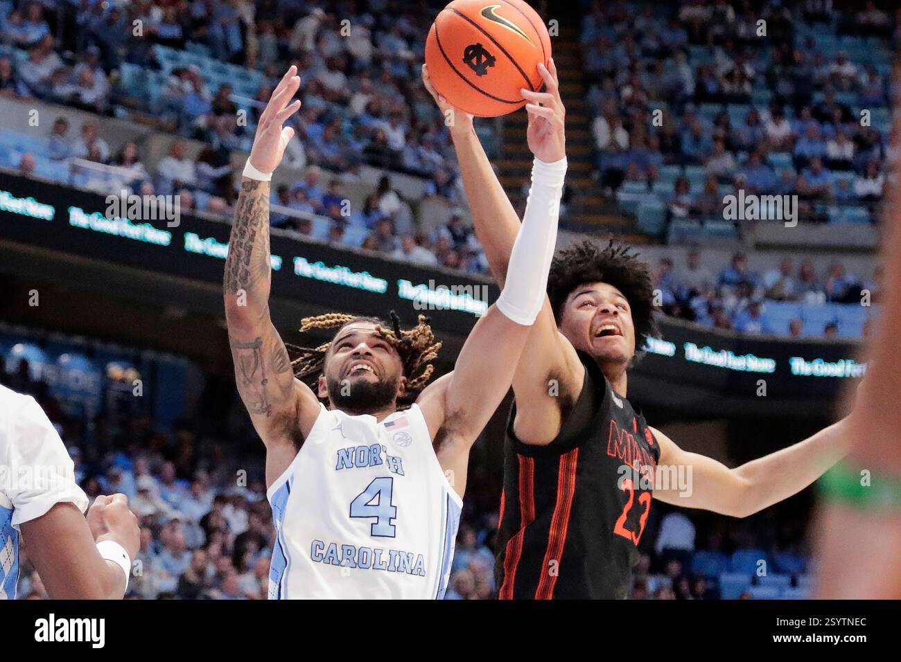 North Carolina guard RJ Davis (4) and Miami guard Austin Swartz (23 ...