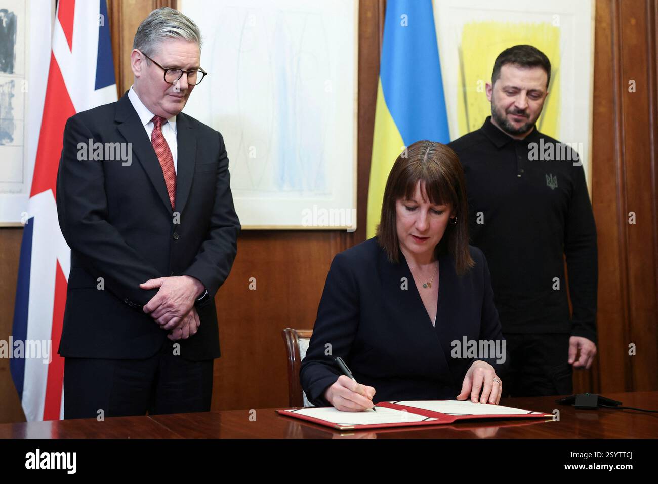 Britain's Chancellor of the Exchequer Rachel Reeves, front, signs a ...