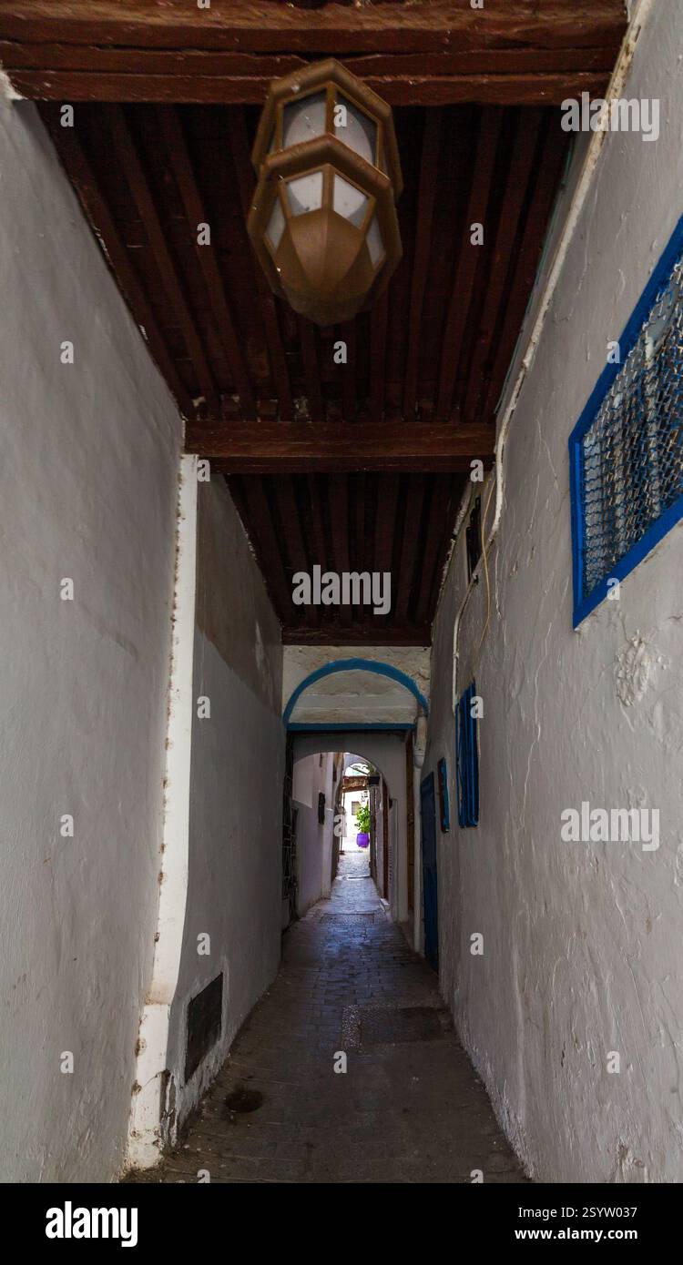 narrow, dimly lit passageway with whitewashed walls, a wooden beamed ...