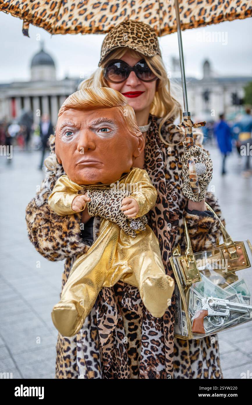 A baby Donald Trump figure is carried by a glamourous lady at a protest ...