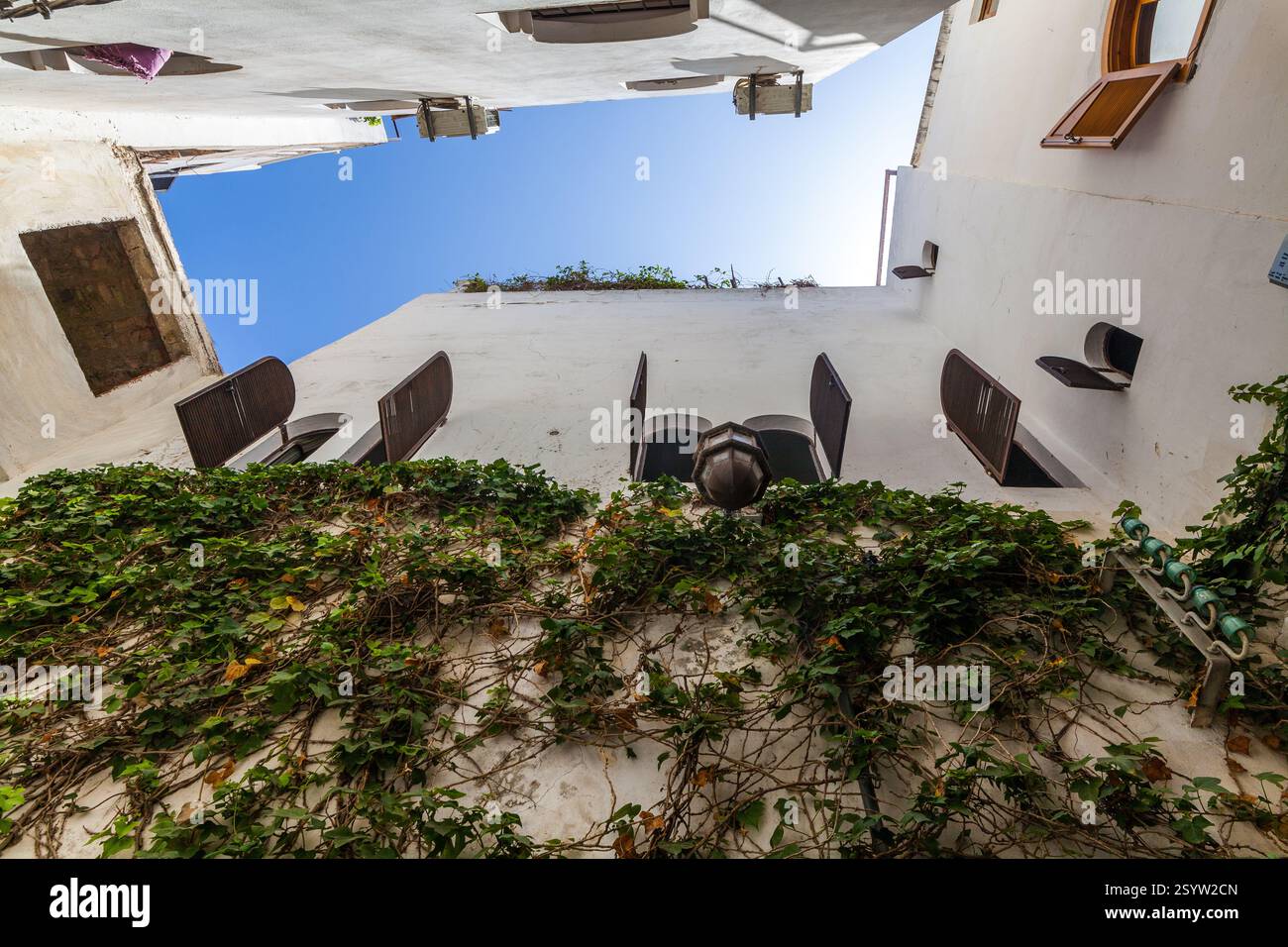 dramatic upward perspective within a narrow courtyard, showcasing ...