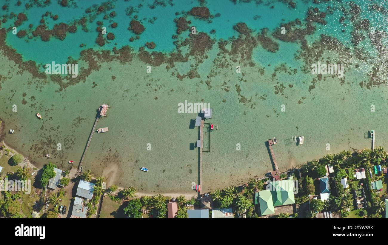 Turquoise water coral reef and tropical island coastline, wooden pier ...