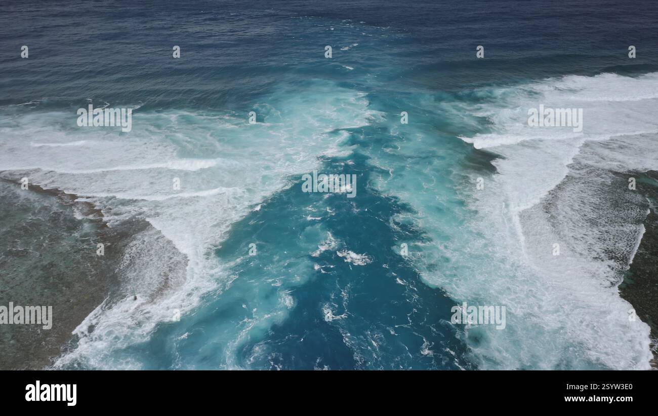 Aerial view of turquoise water creating a passage between coral reefs ...