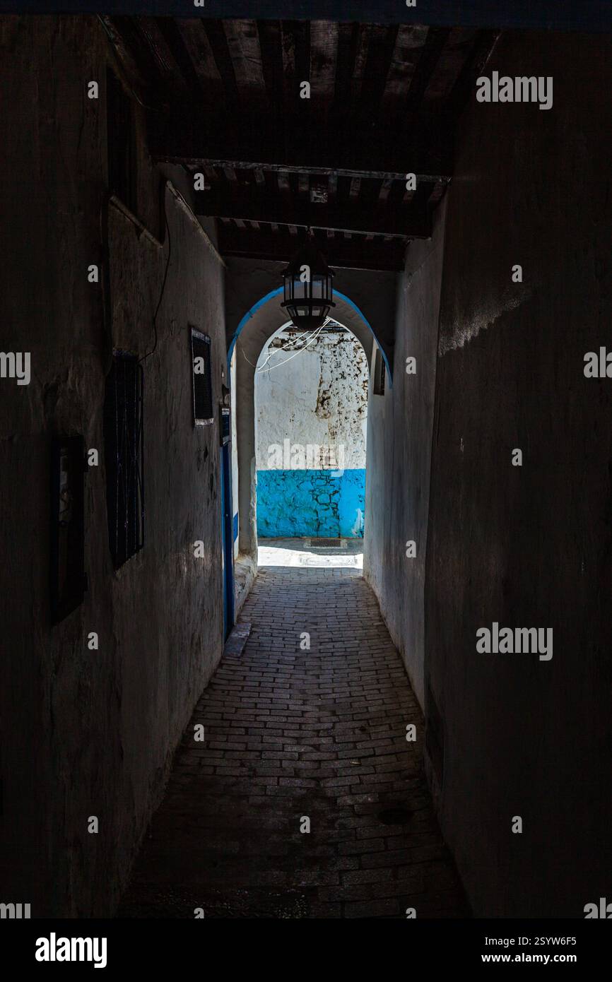 narrow, dimly lit passageway with whitewashed walls, a wooden beamed ...