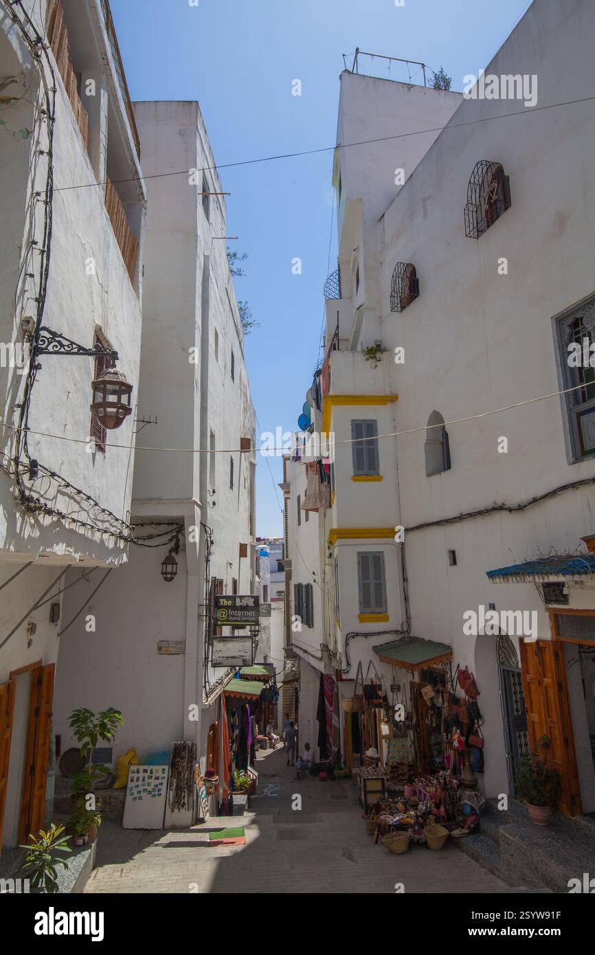 narrow, bustling street in a Mediterranean town, lined with whitewashed ...