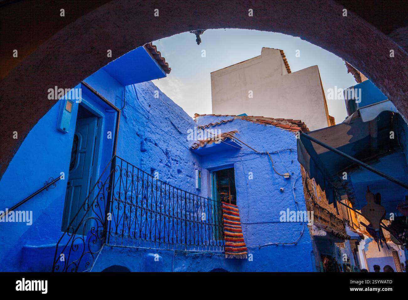 view of blue-washed buildings framed by an archway, showcasing the ...