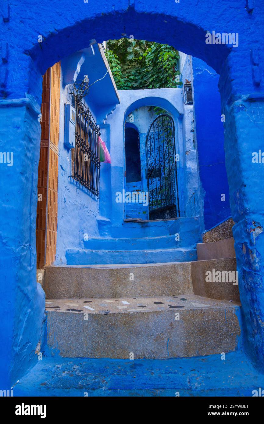 view through a blue archway, revealing a blue staircase and buildings ...