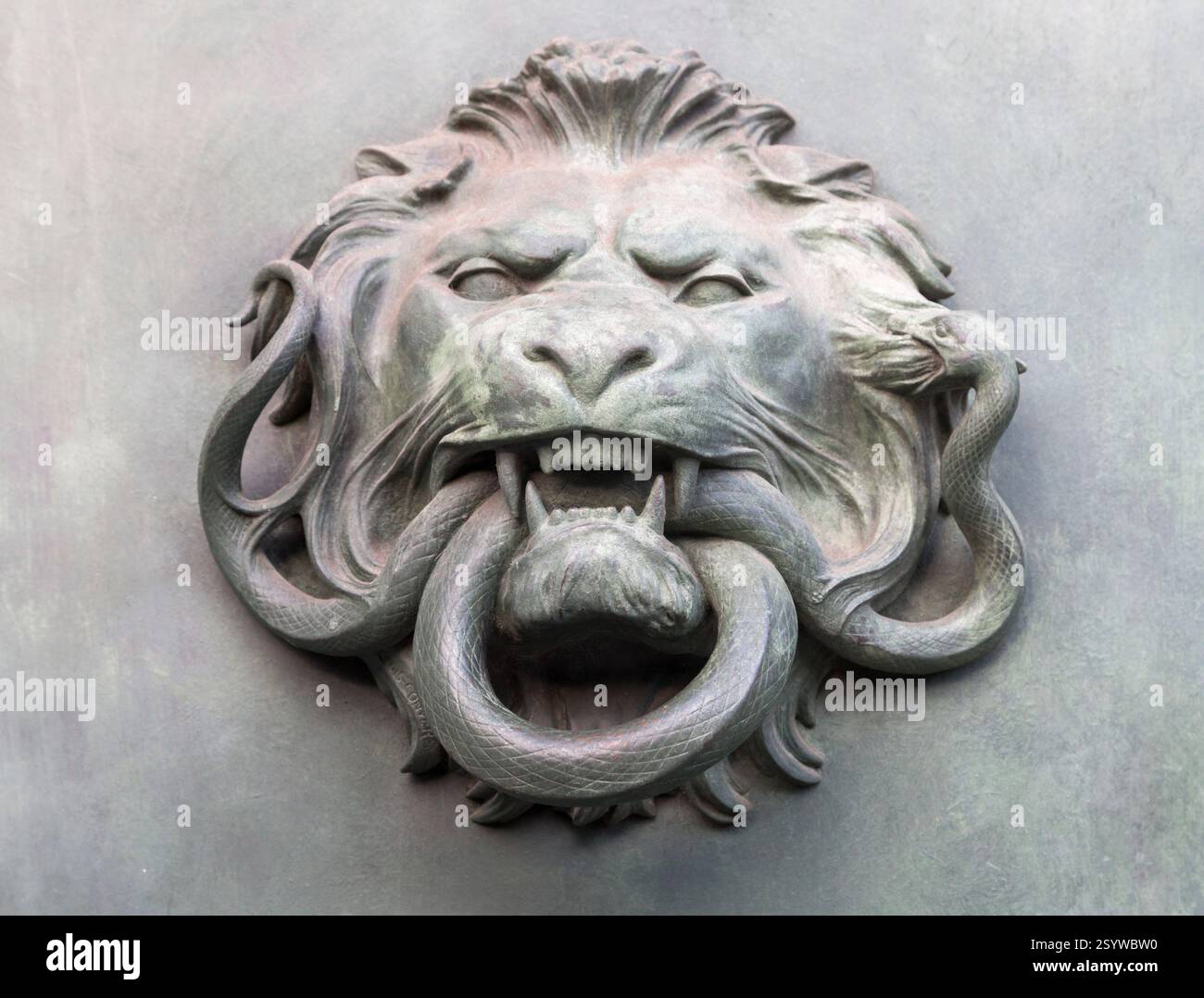 A detailed lion head sculpture features intertwined snakes ...