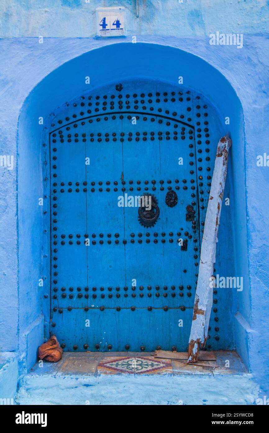 vibrant blue arched wooden door with decorative studs and a knocker ...