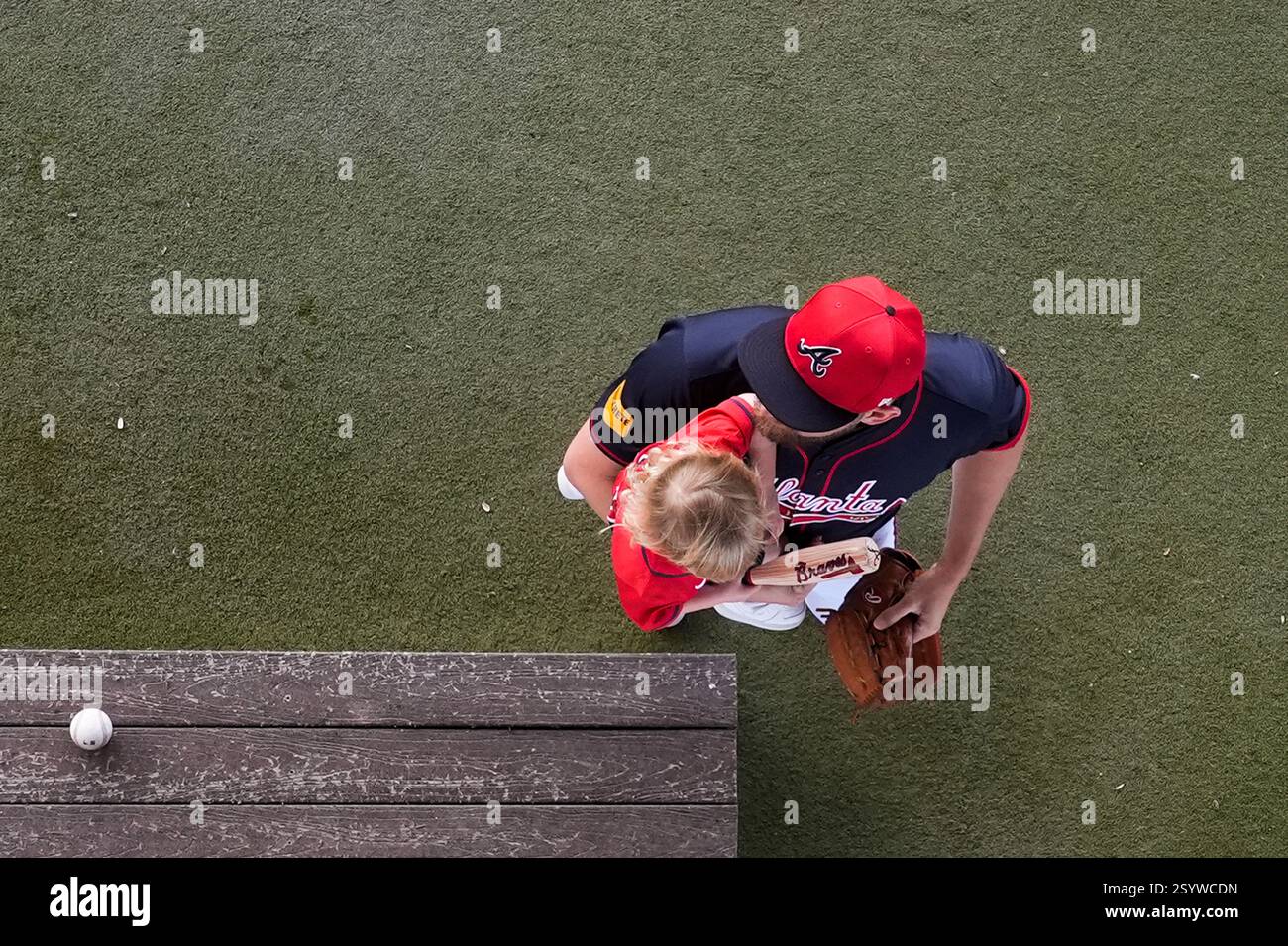 Atlanta Braves starting pitcher Dylan Lee (52) holds a child as he ...