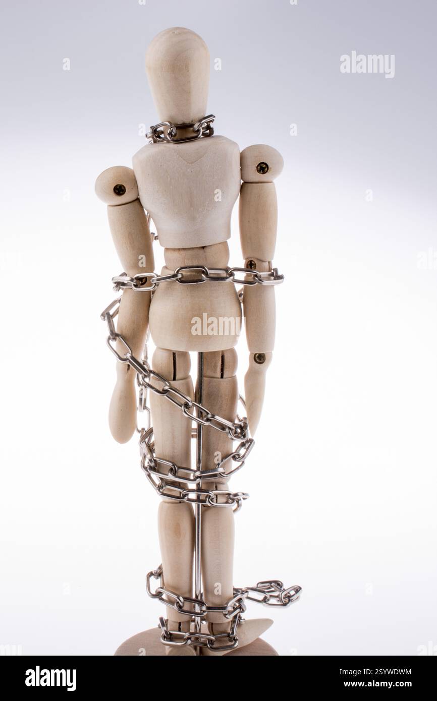 Wooden model man in chains on a white background Stock Photo - Alamy