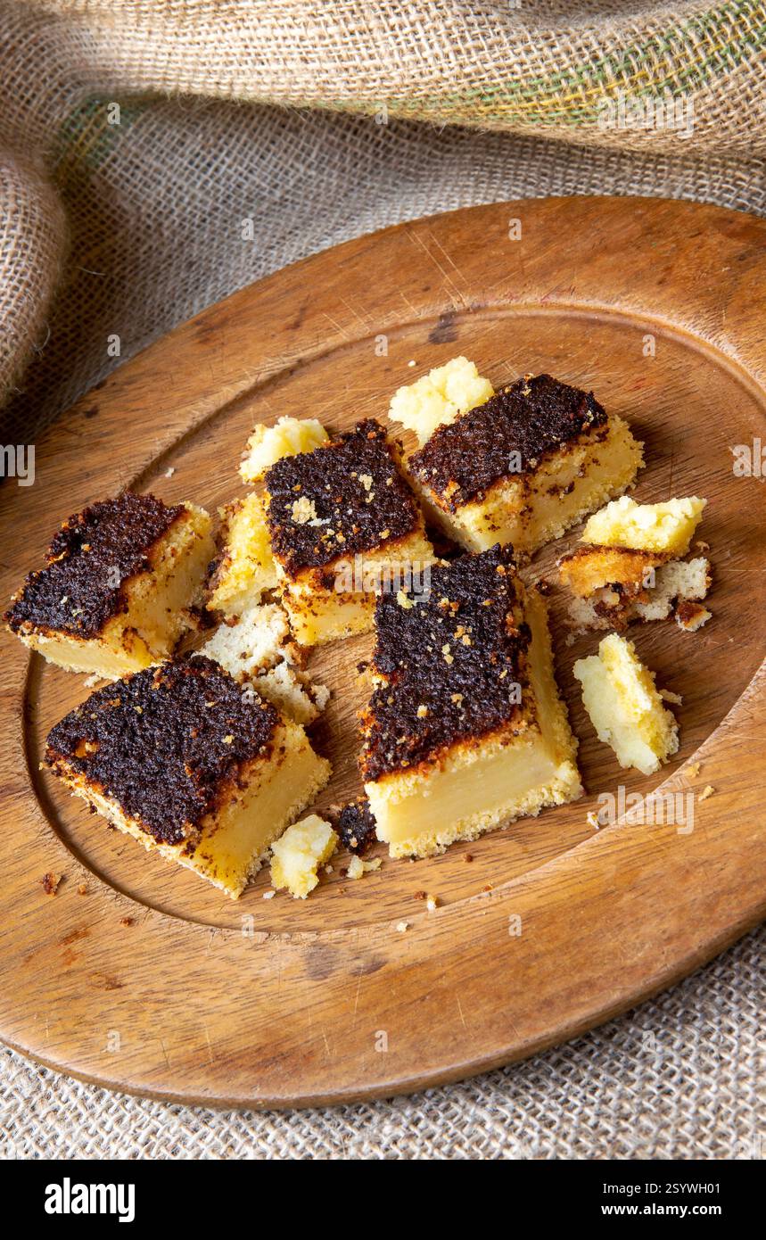 Brazilian creamy corn cake made with a type of corn flour, on wood rustic plate. Typical in ...
