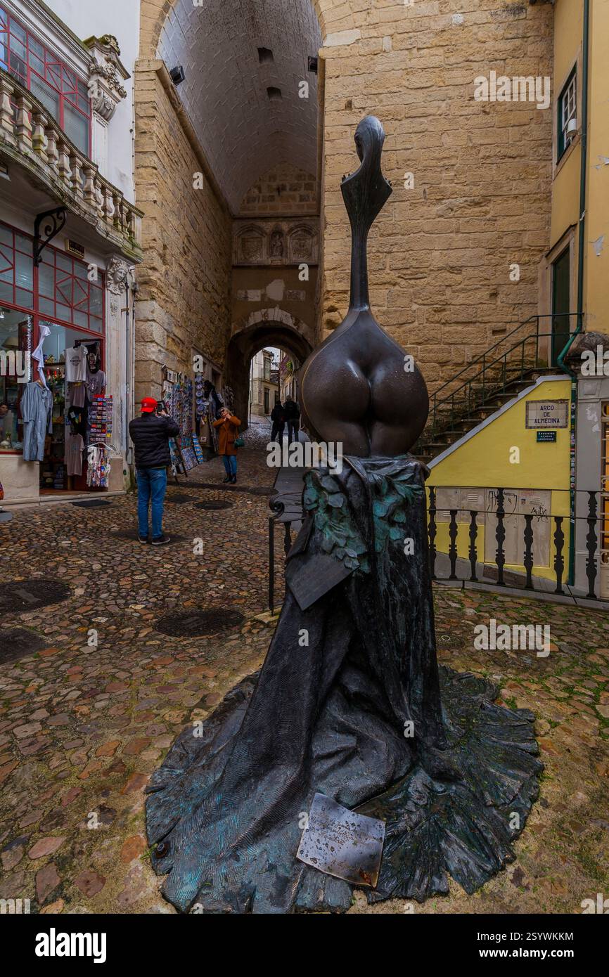 A bronze statue of a stylized lute player stands in a cobblestone ...