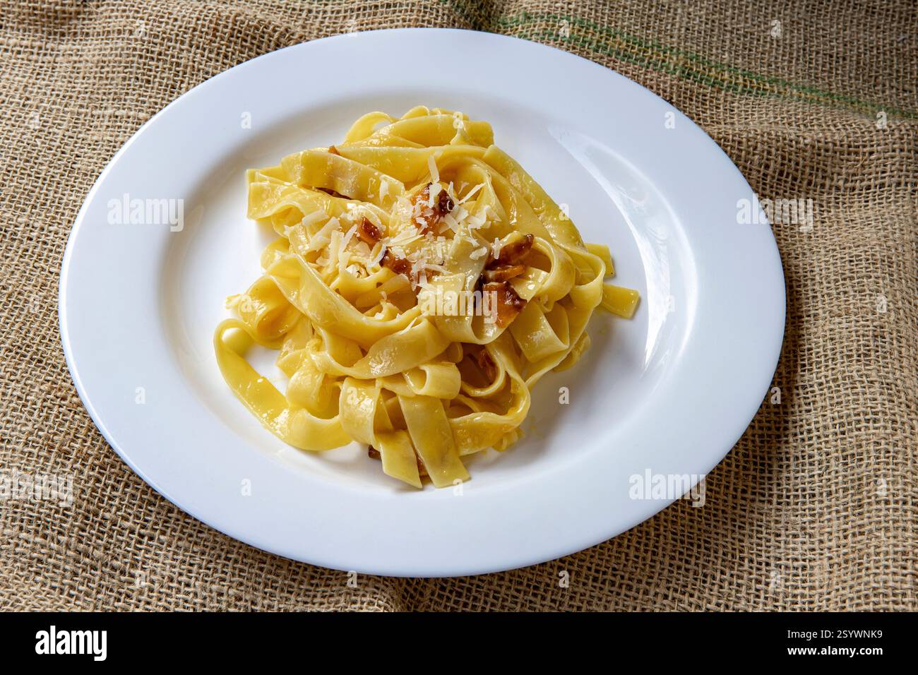 Plate of tagliatelle alla carbonara italian food in a rustic jute ...