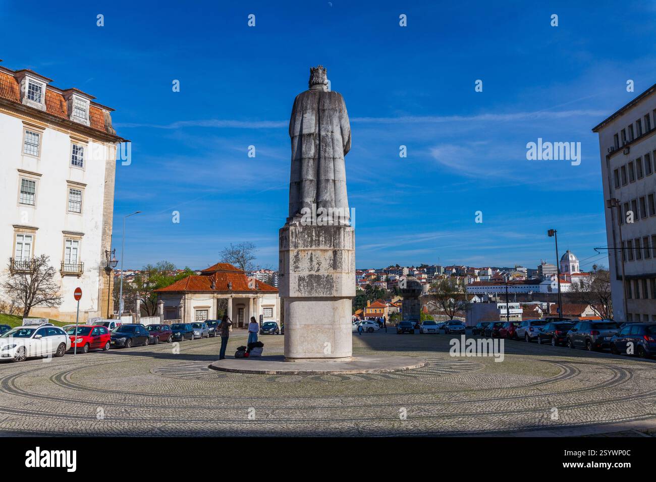 A tall stone statue of a robed figure stands prominently in a circular ...