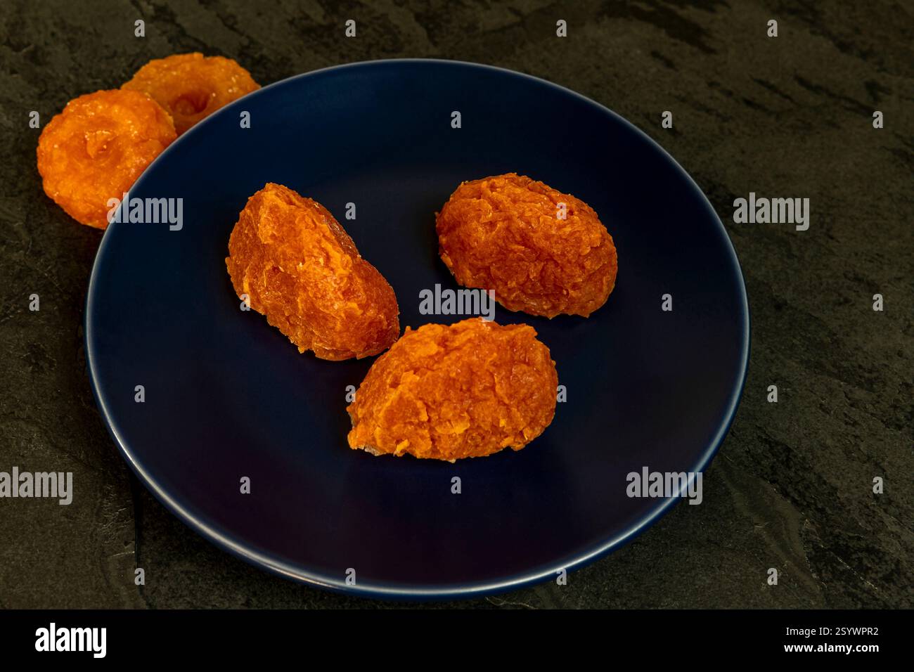 Pumpkin candy, brazilian dessert on blue dish and dark background ...