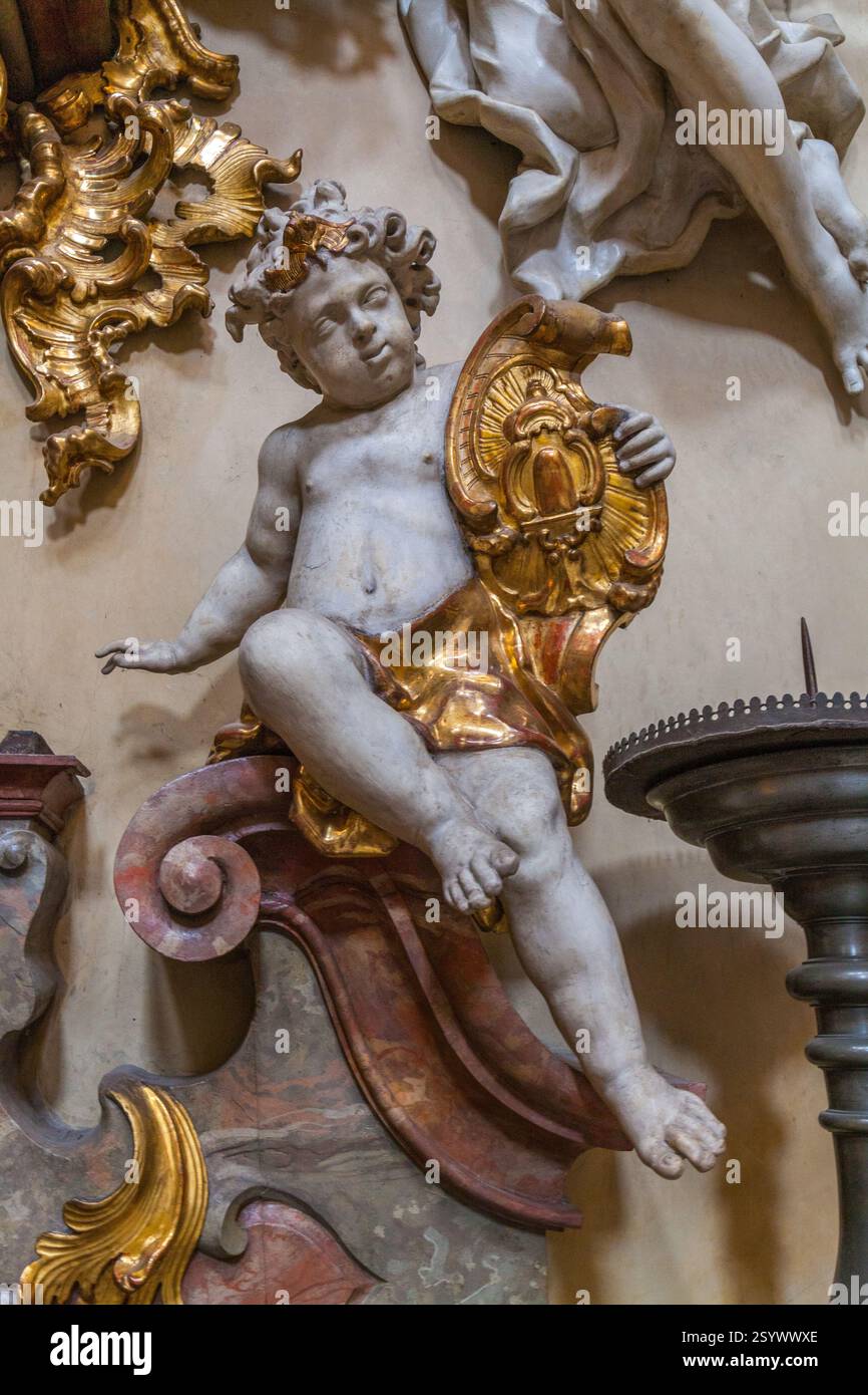 Close-up of a statue of a cherubic figure with a golden garment ...