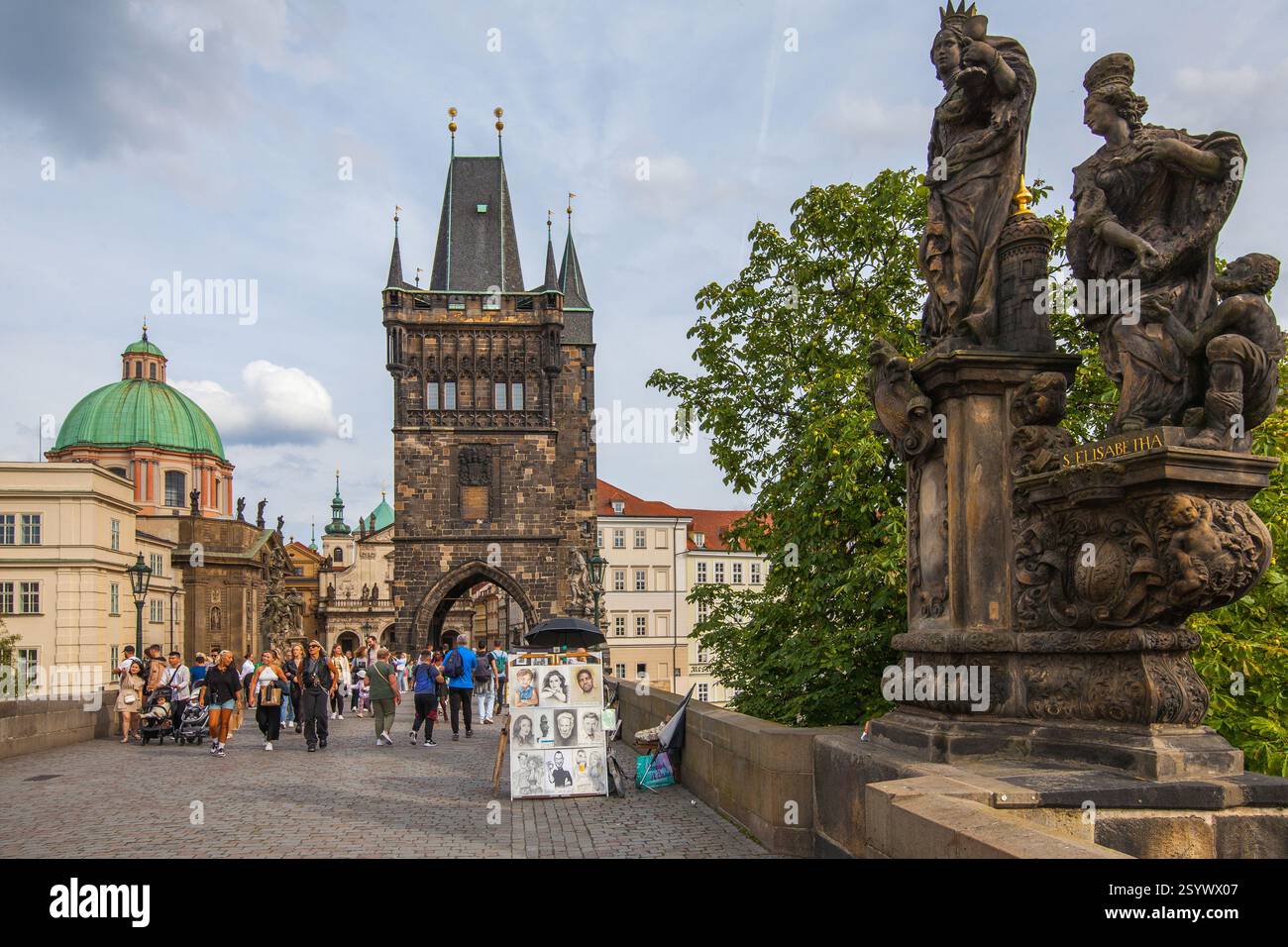 A bustling stone bridge featuring historic towers, ornate statues, and ...