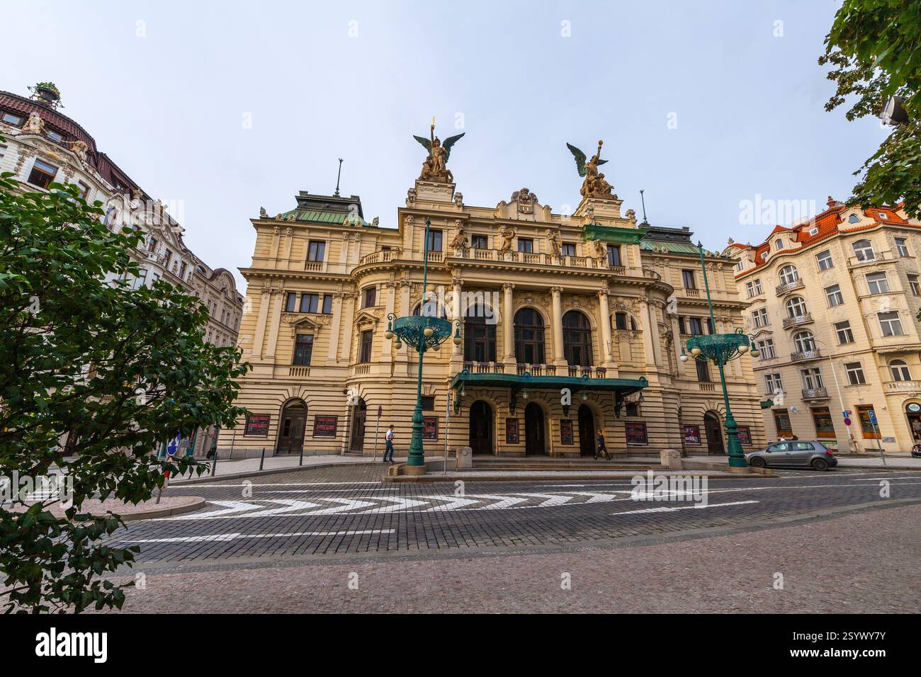 A grand, ornate theater building with statues atop its entrance and ...