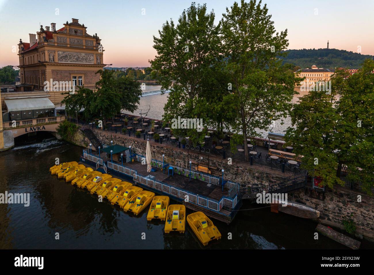 A waterfront scene featuring a building with a sign, a platform with ...