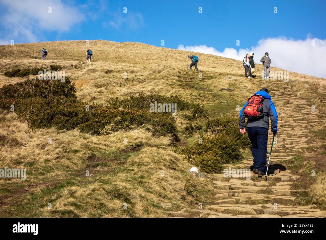 Man climbing the flagstones up to the summit of Mam Tor the highest ...