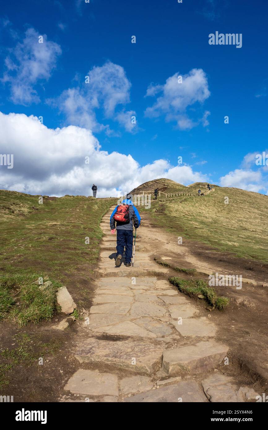 Man climbing the flagstones up to the summit of Mam Tor the highest ...