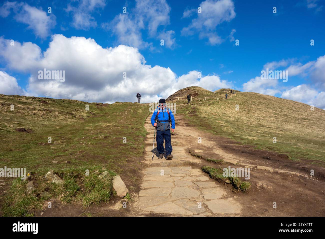 Man climbing the flagstones up to the summit of Mam Tor the highest ...