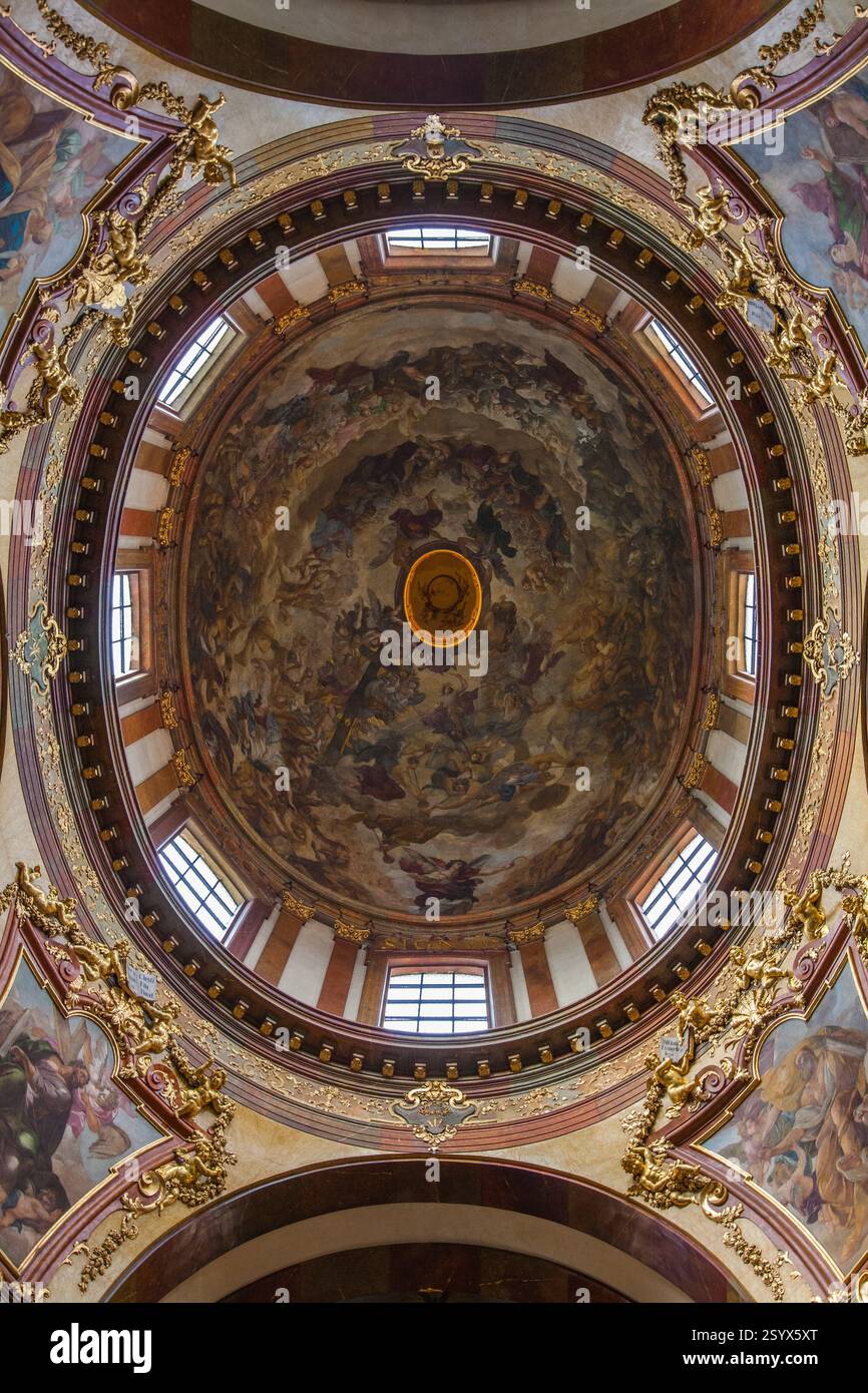 A low-angle shot of an ornate dome interior in a baroque church ...
