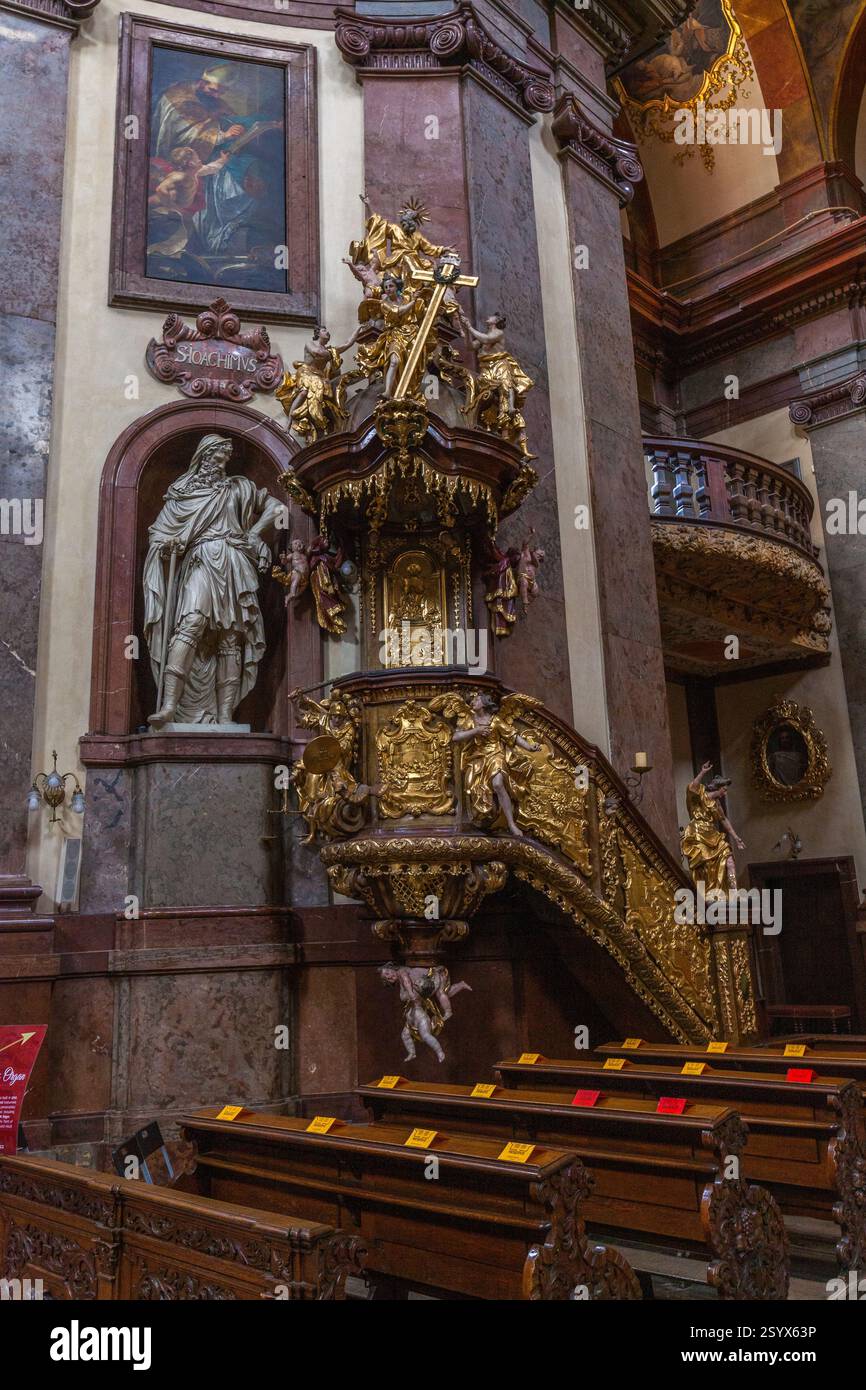 A baroque church interior featuring an ornate pulpit with gilded ...