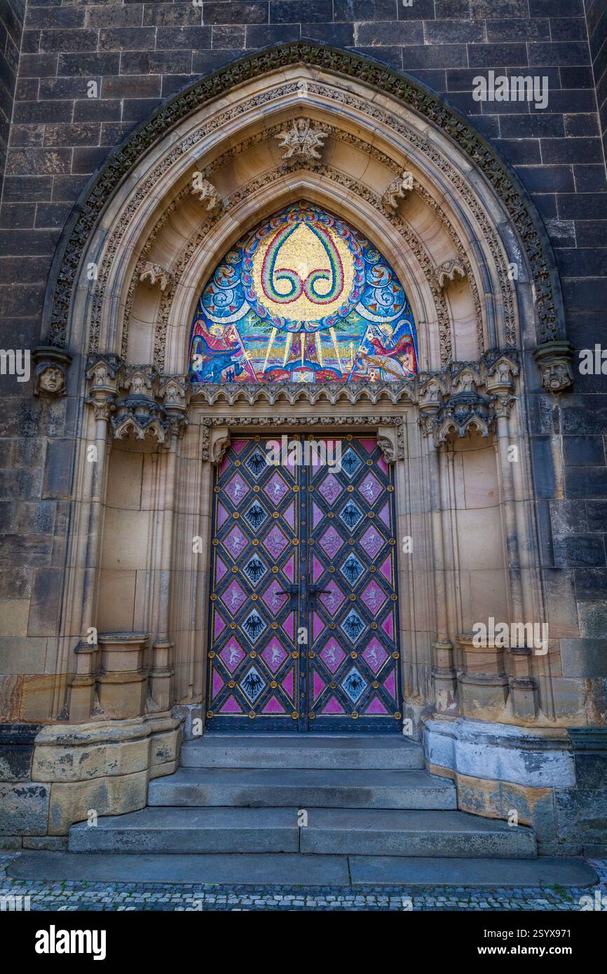 A detailed view of an arched entrance featuring a colorful mosaic above ...