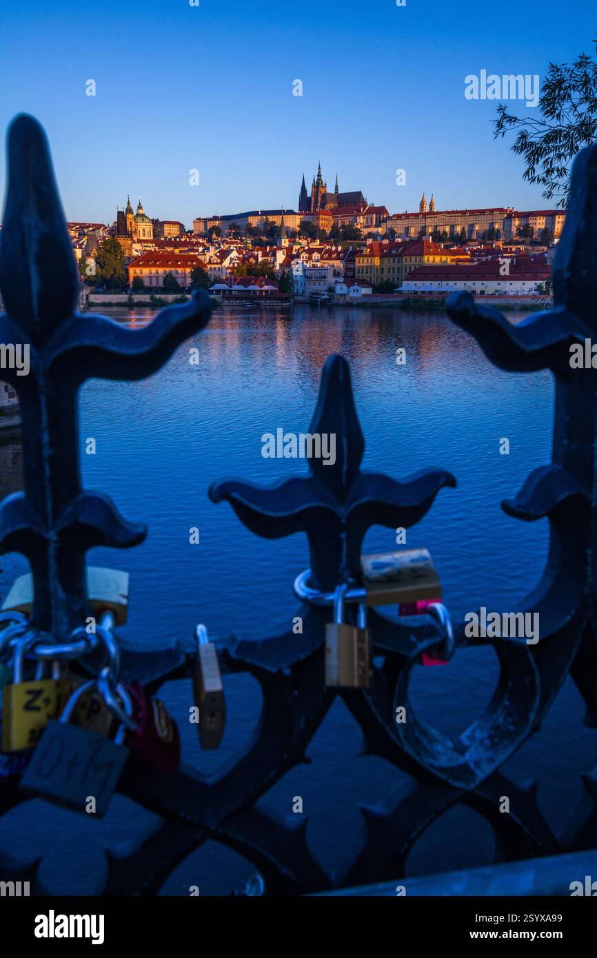 A twilight cityscape view through an ornate metal railing with love ...