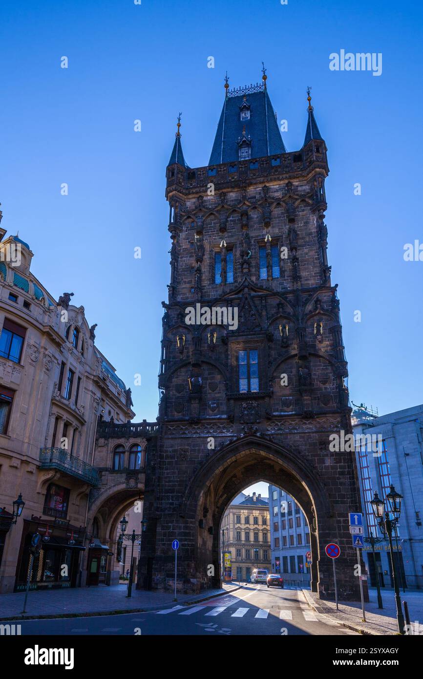 A tall, gothic tower with a dark spire and arched gateway stands ...