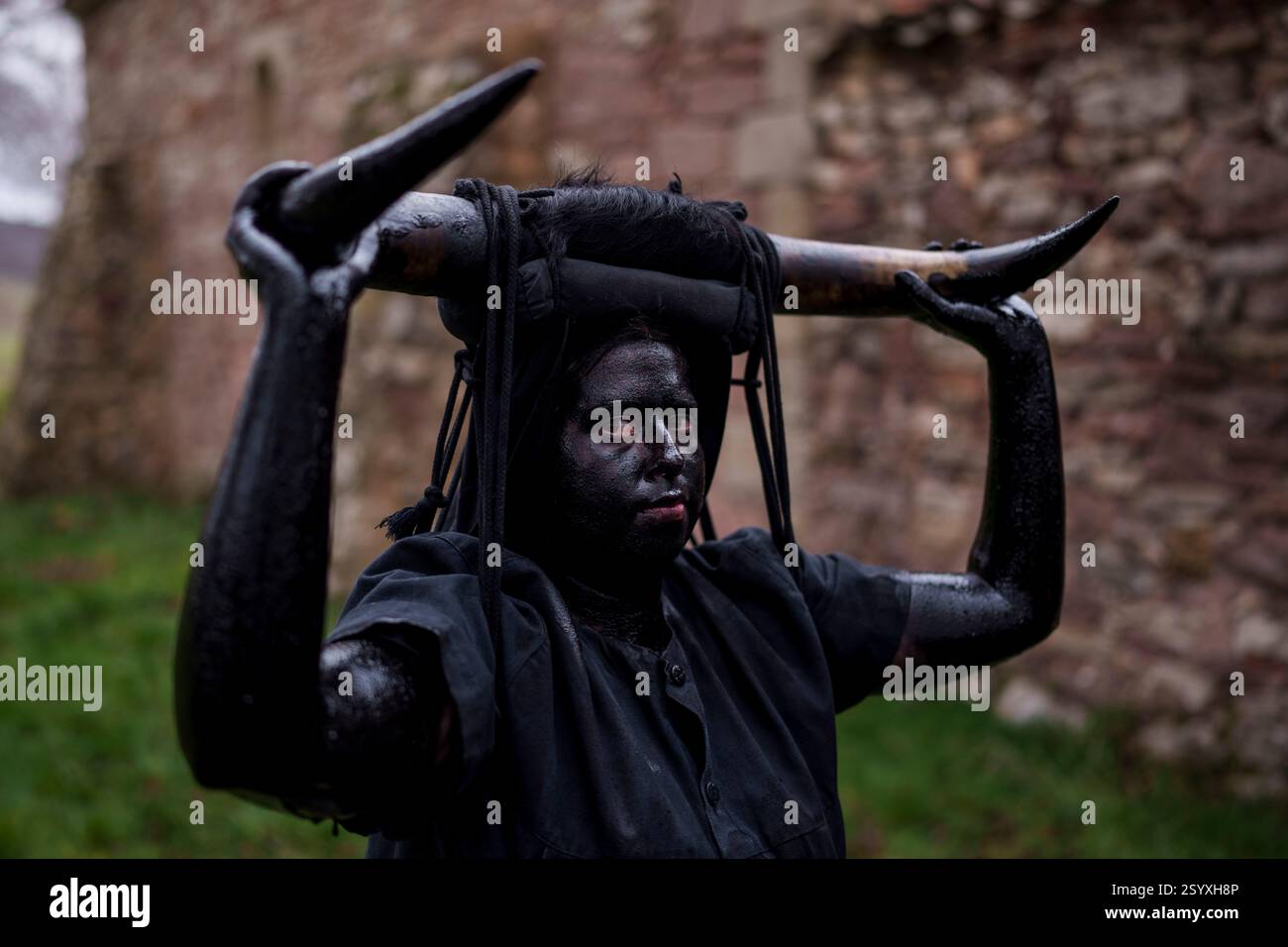 A reveler, dressed as "Diablos de Luzon" or Luzon Devil's, covered in ...