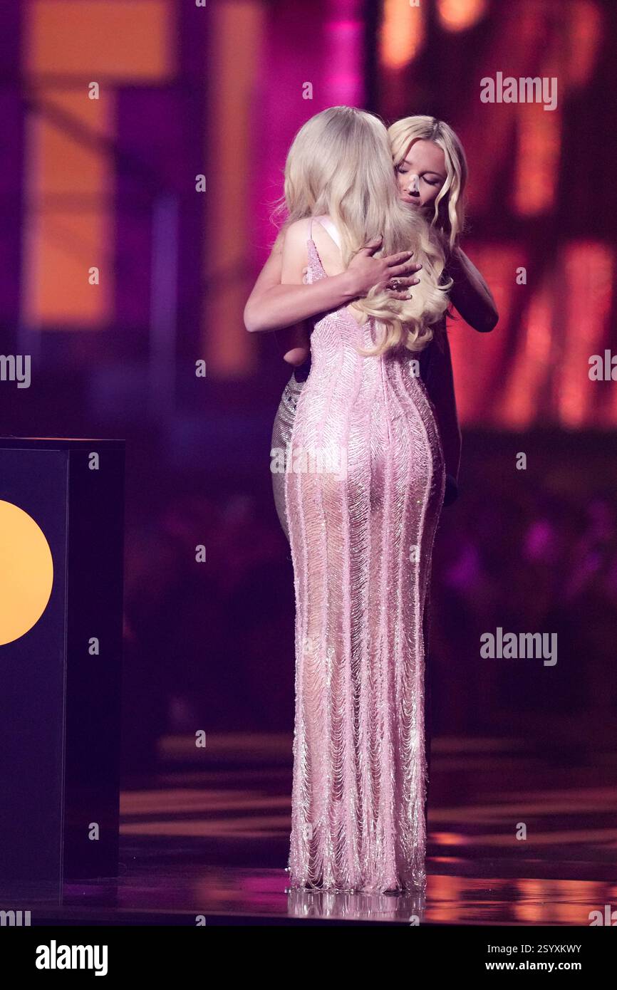 Sabrina Carpenter, left, winner of the global success award, embraces ...