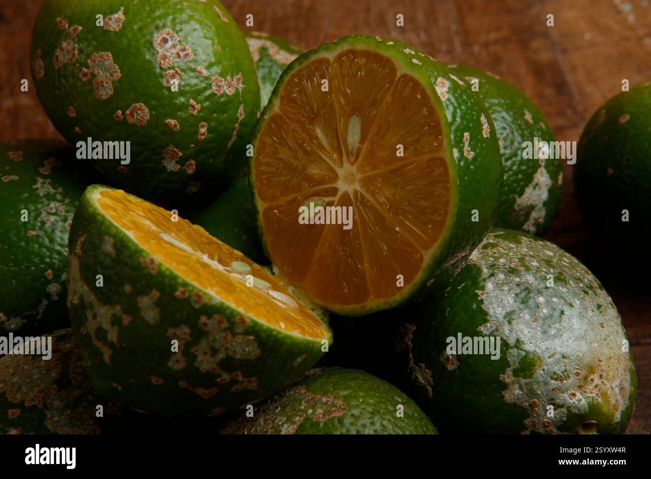 Group of juicy ripe Rangpur limes spread on a wooden table. Rangpur ...