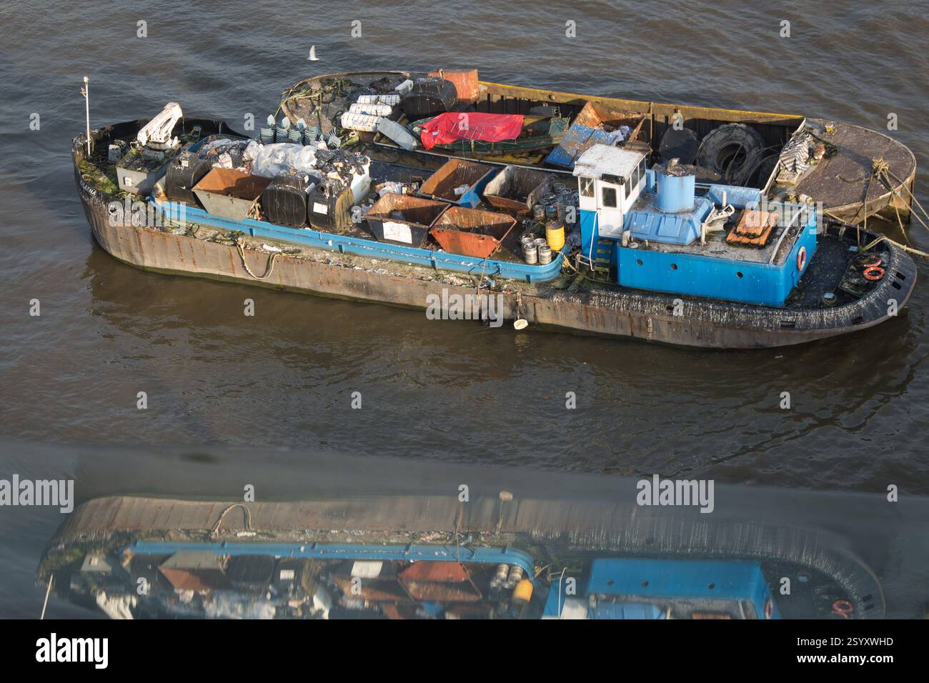A barge, the "Elena," carrying refuse, floats on the River Thames ...