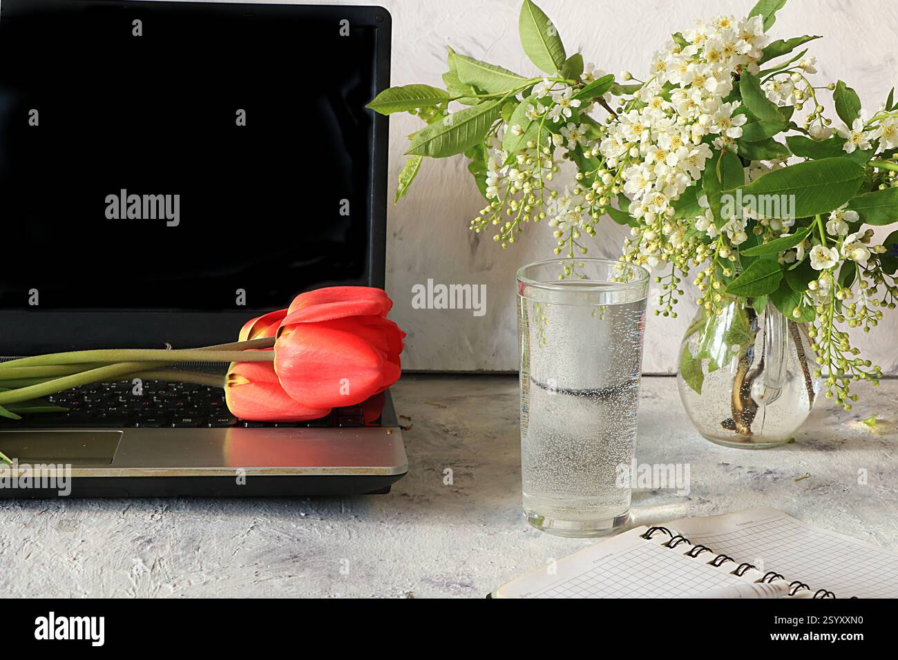 Modern office worker desktop with computer, notebook, glass of clear ...