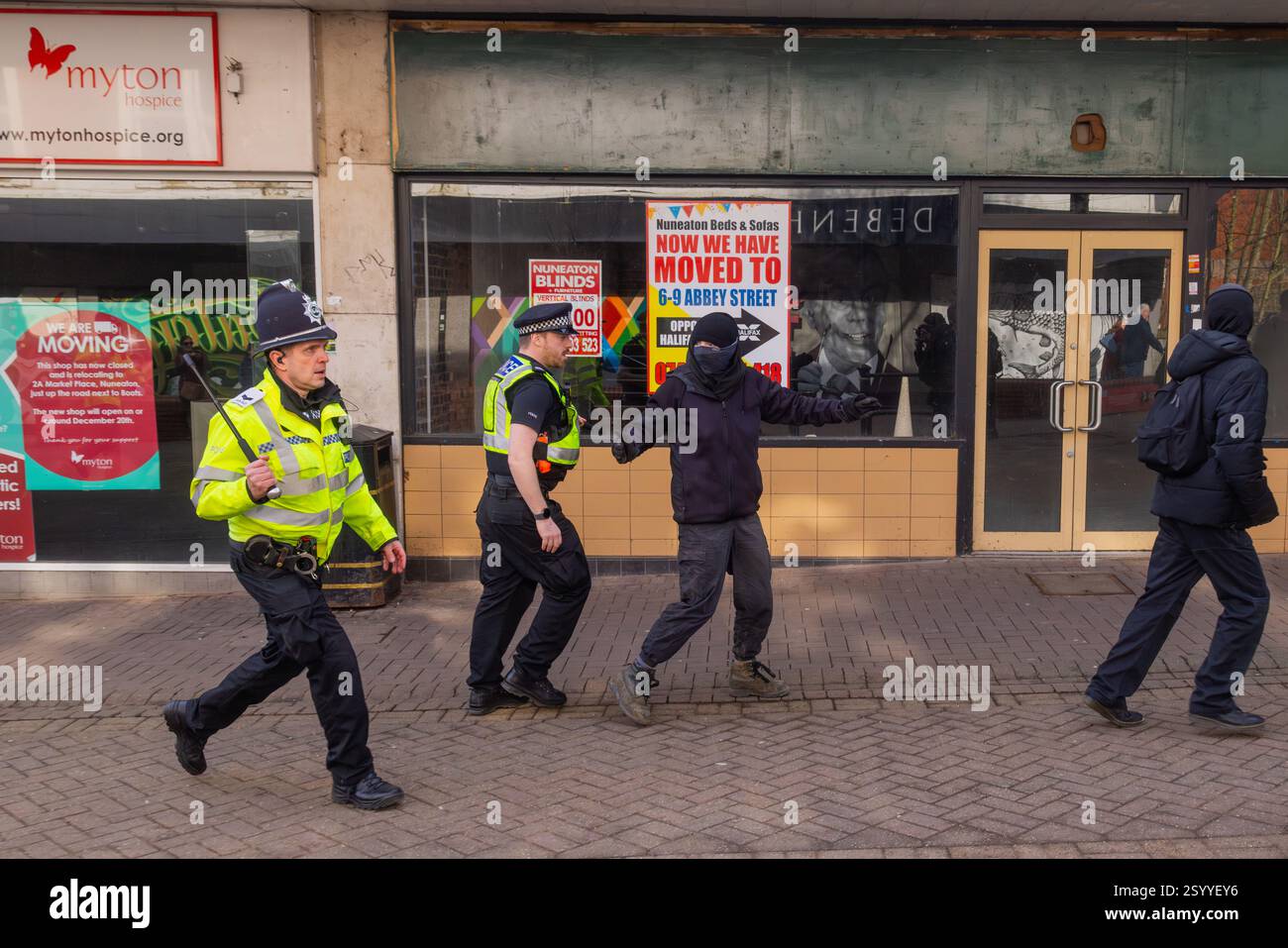 Nuneaton, UK. 01 MAR, 2025. Police with batons grapple with masked ...