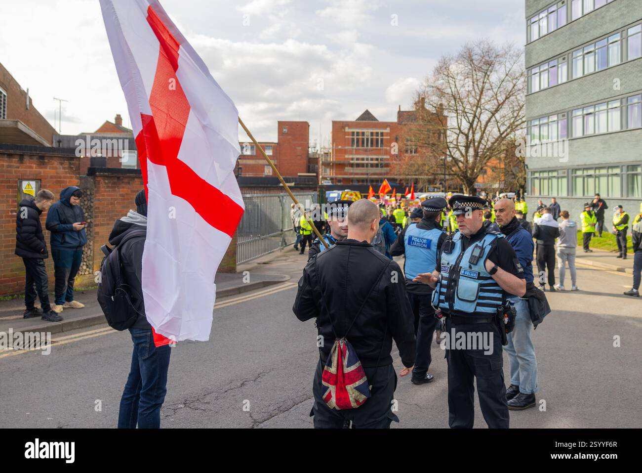 Nuneaton, UK. 01 MAR, 2025. Police talk to man waving england flag as ...