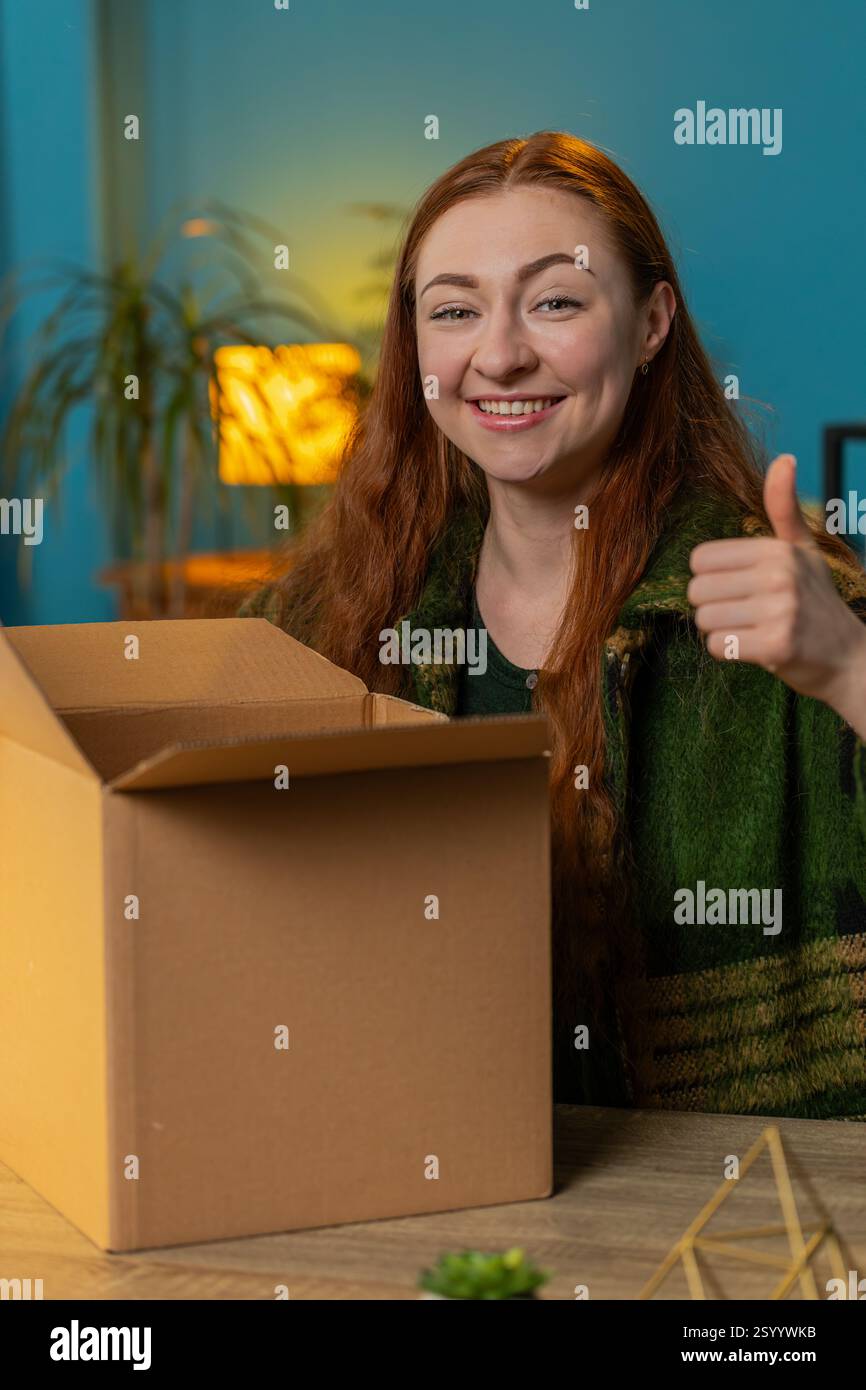 Happy excited woman unpacking delivery parcel. Smiling satisfied girl ...